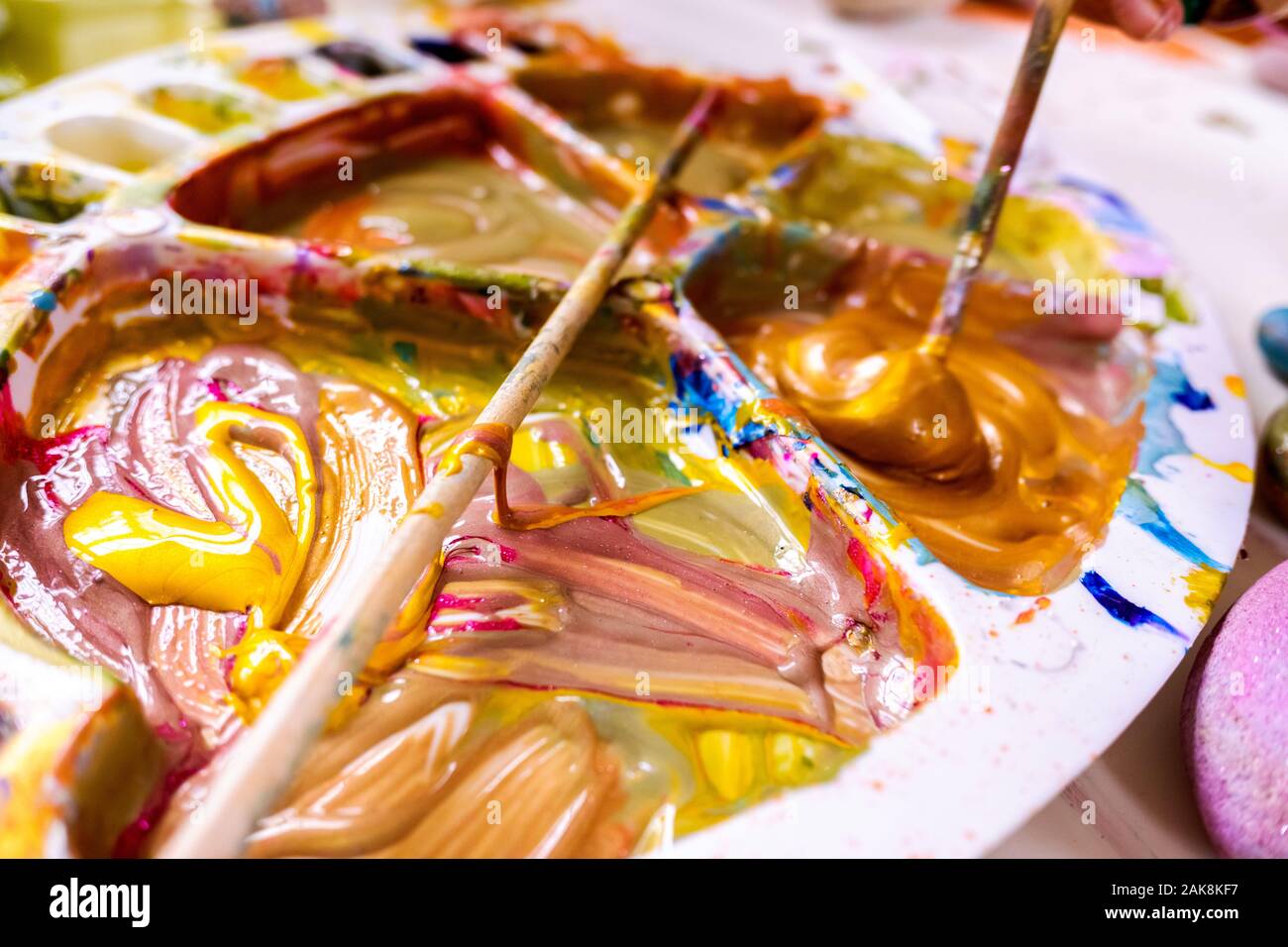 Detail of the mixed colored paintings on the palette of an artist ...