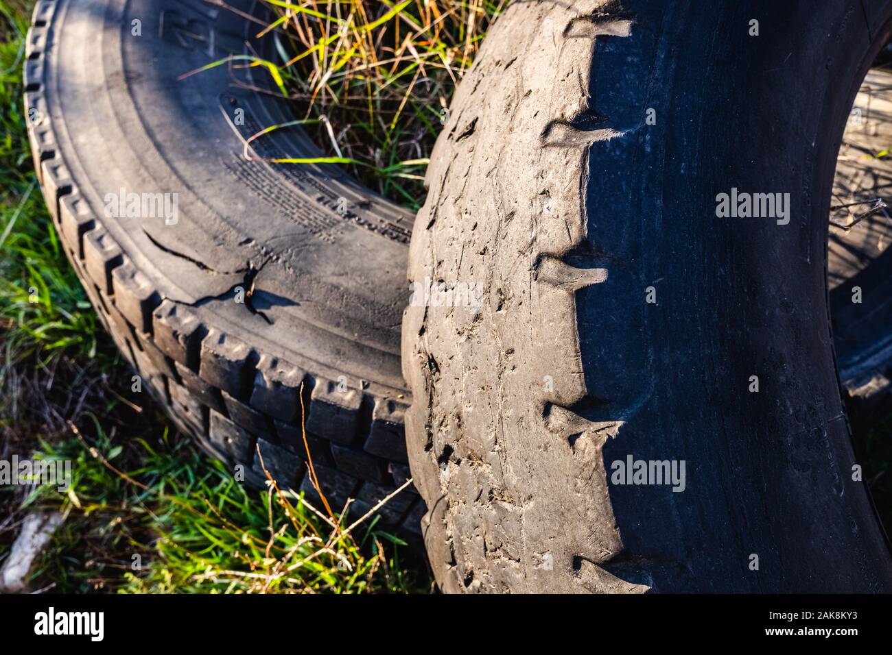 Old wheels of unrecycled cars thrown in a natural field pollute the ...