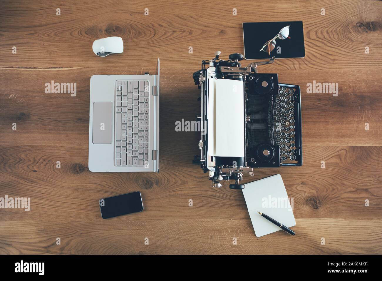 Then and now . Wooden desk with old fashioned typewriter back-to-back ...
