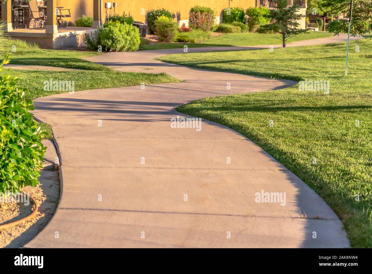 Close up of narrow paved pathway winding through lush grasses on a ...