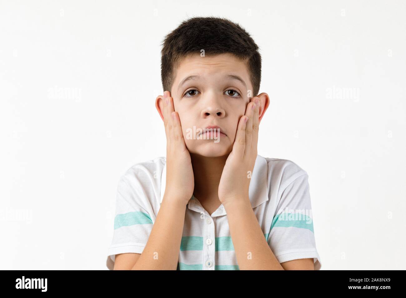 offended sad little child boy in striped t-shirt on white background ...