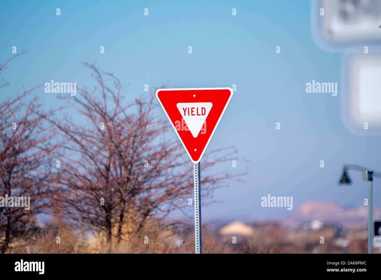 Red traffic Yield sign alongside a road Stock Photo - Alamy