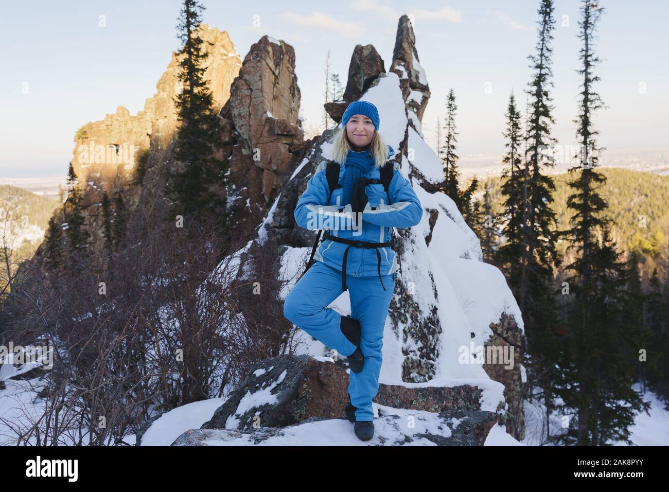 Young female hiker wanderlust with blonde hair reaching up top of ...