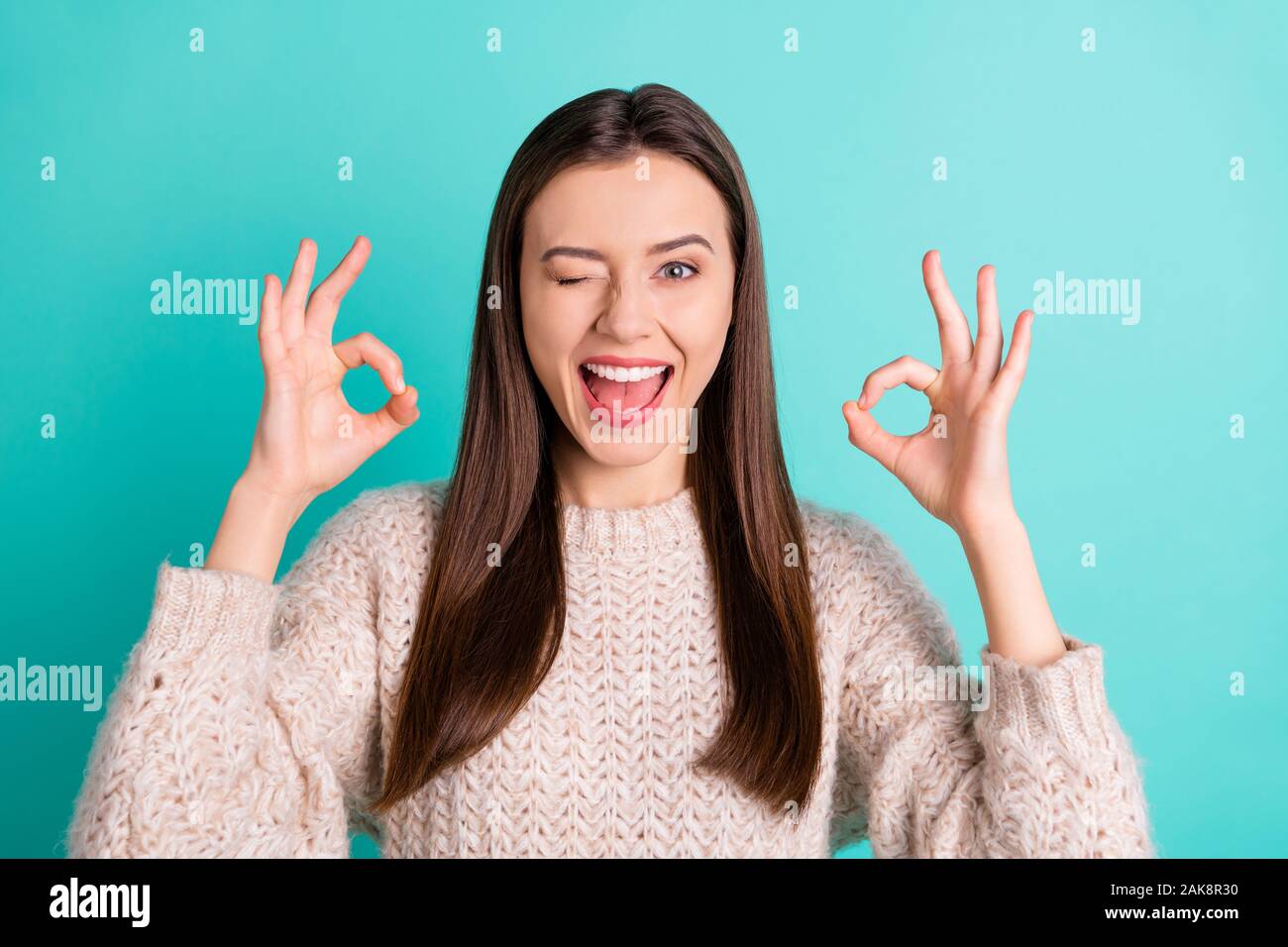 Portrait of cheerful positive girl laughing showing okay sign present ...