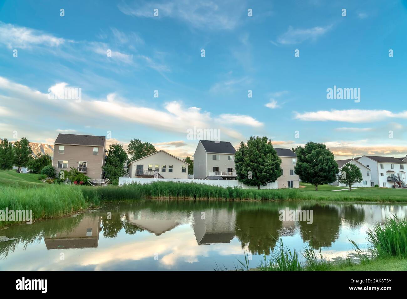 Scenic suburban landscape with homes and cloudy sky reflected on a ...