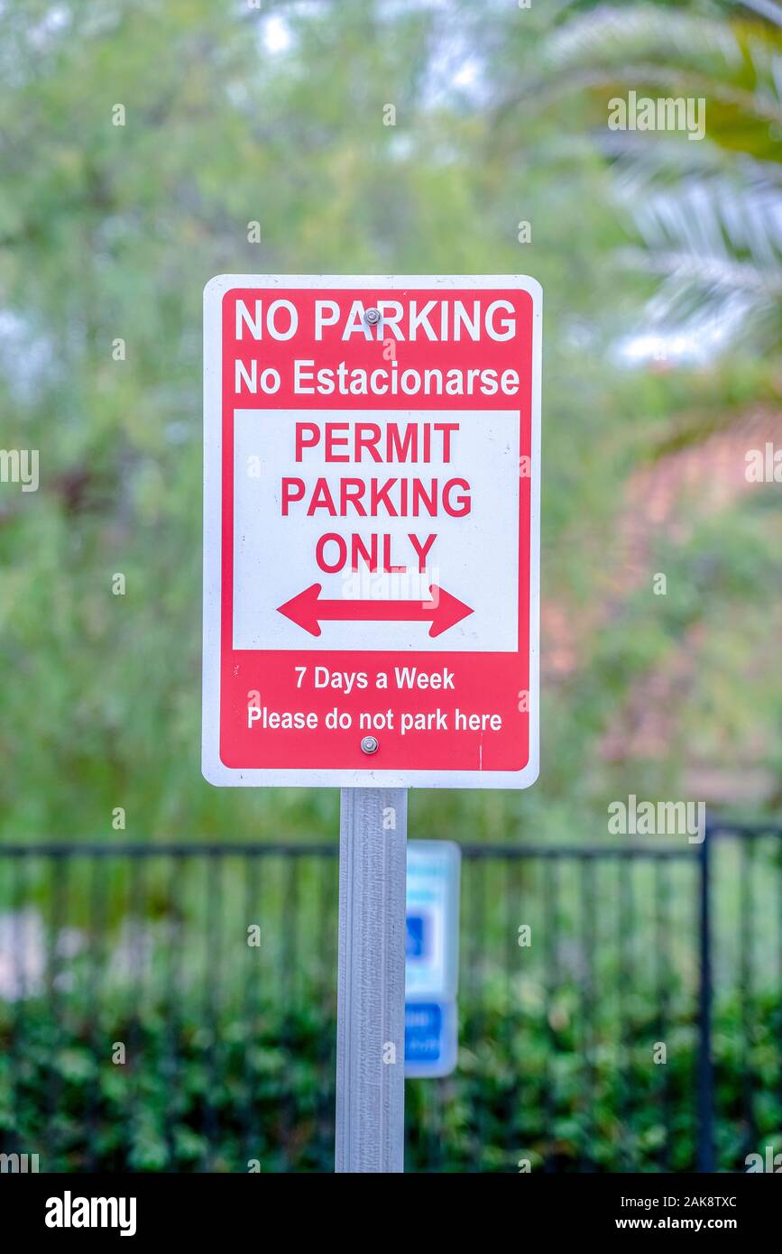 Red No Parking warning sign duplicated in Spanish Stock Photo - Alamy