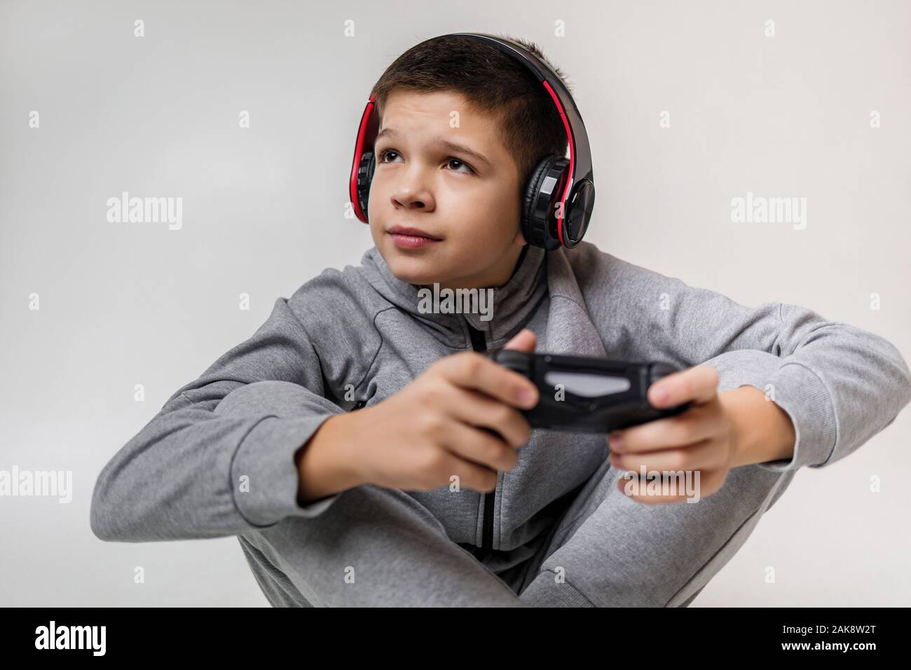 child boy playing video games over gray background. young gamer playing ...