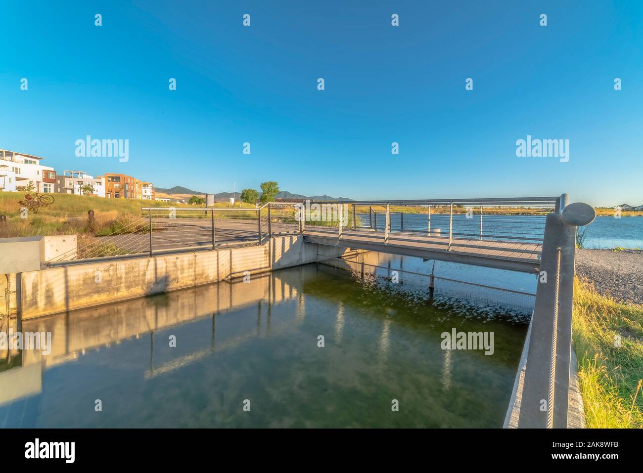Bridge over lake with lakefront buildings and mountain view under blue ...