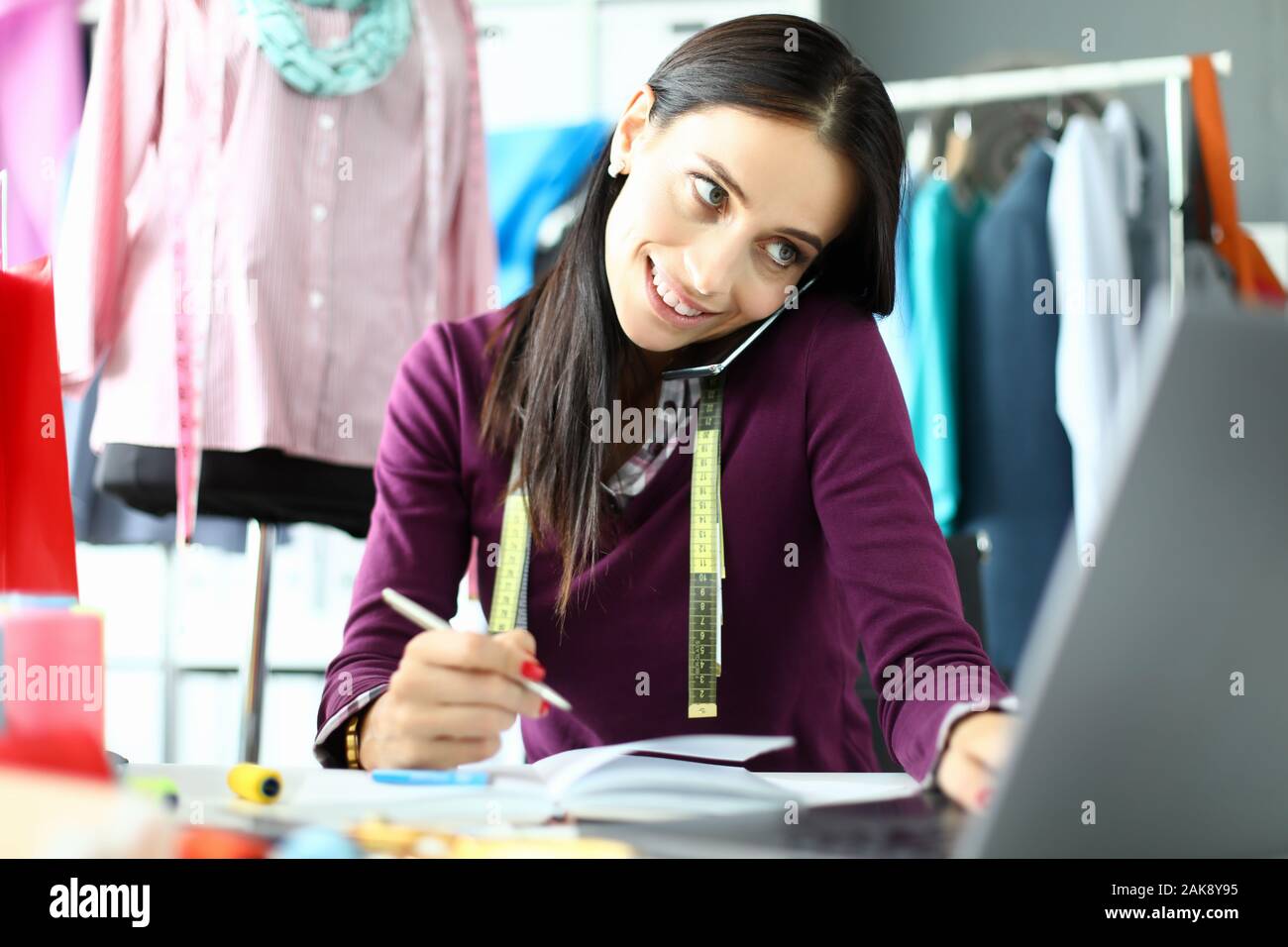 Smiling professional female dressmaker Stock Photo - Alamy