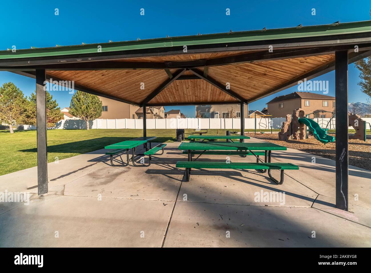 Picnic tables under a wooden roof in a park Stock Photo - Alamy