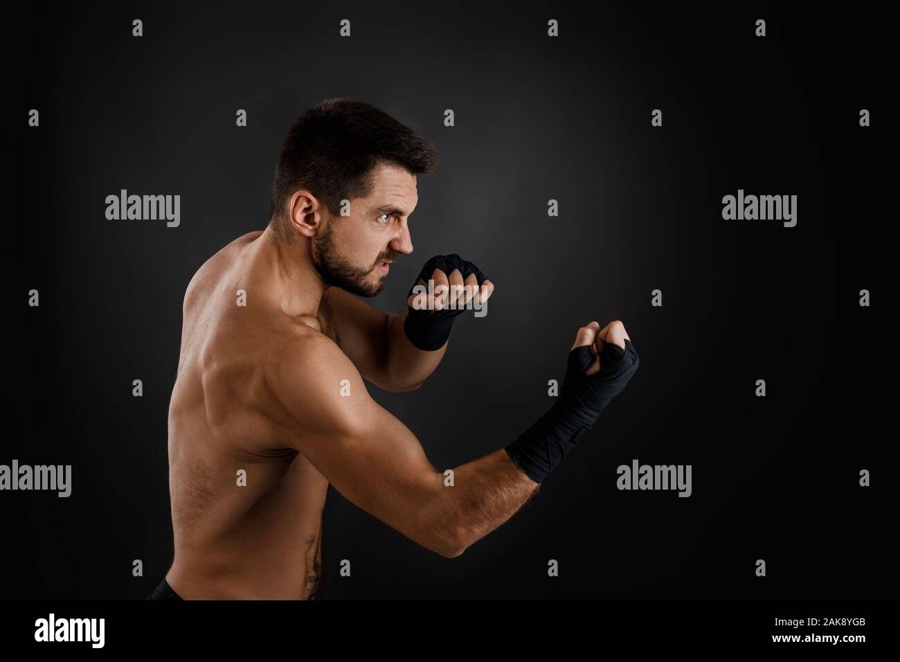 Sportsman boxer throwing a fierce and powerful punch. muscular man on ...