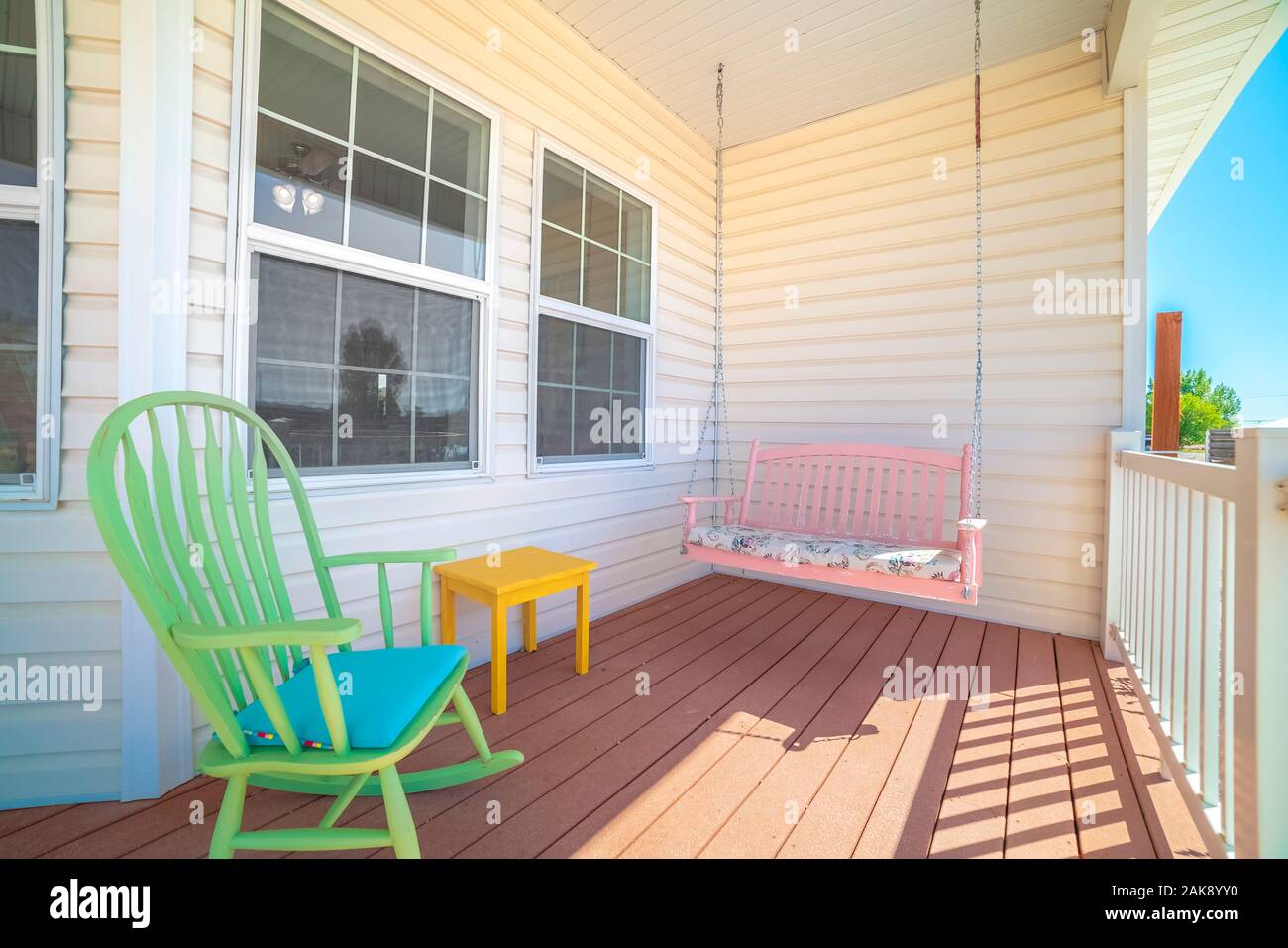 Colorful green rocking chair and pink bench Stock Photo - Alamy