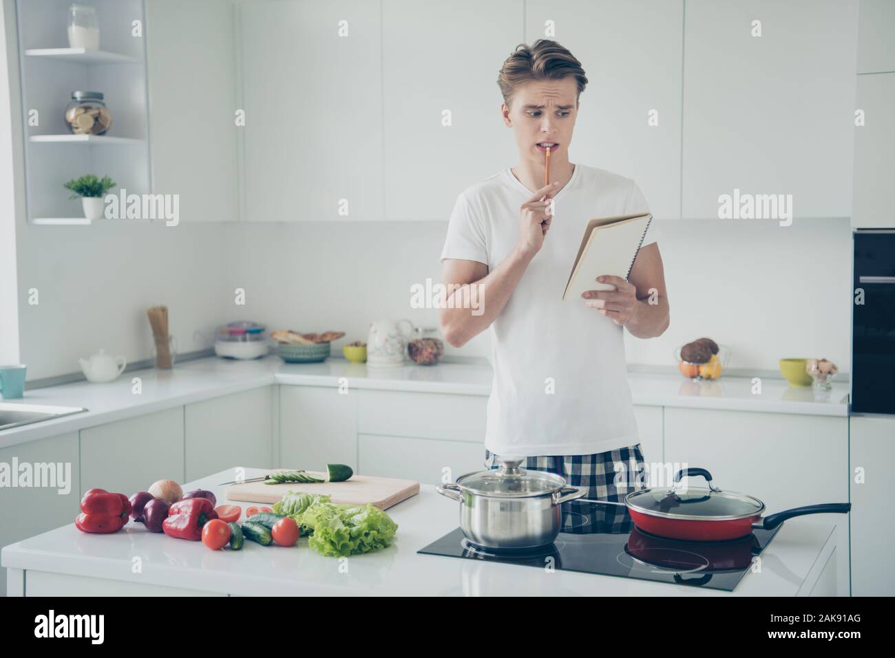 Portrait of his he nice attractive confused guy making lunch writing ...