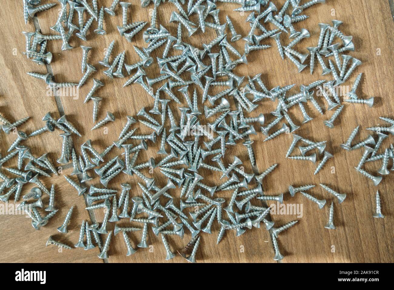 Chrome screws scattered on the floor, repair concept Stock Photo - Alamy