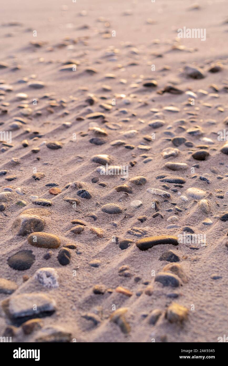 Full frame of small pebbles and stones a wind blown sandy beach Stock ...