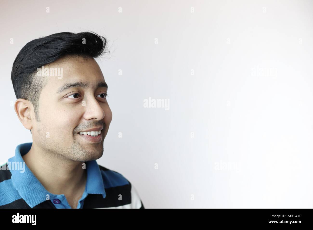 side face of a young indian man isolated in white background with copy ...