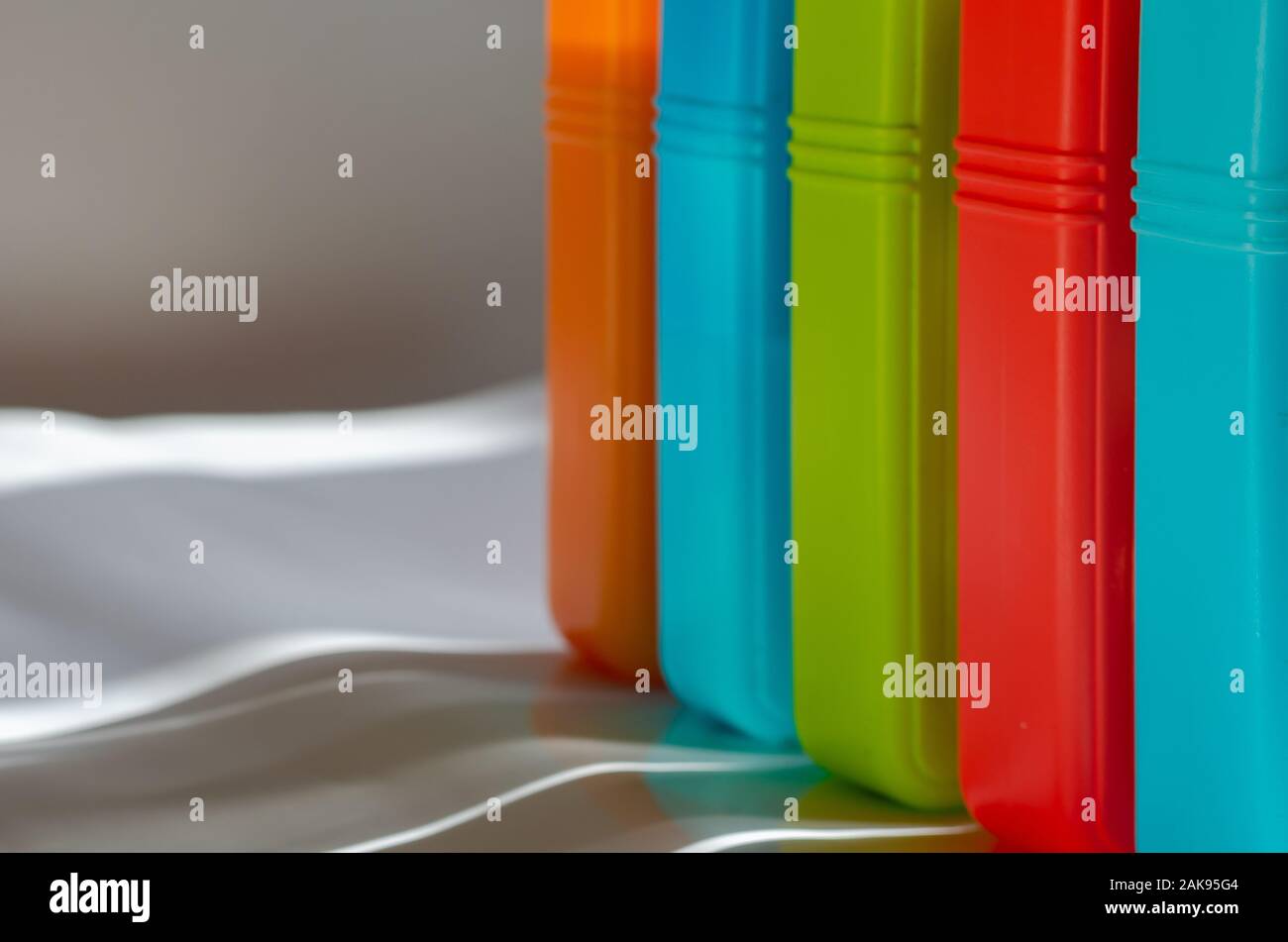 Multi-colored plastic containers. Close-up of five containers for ...