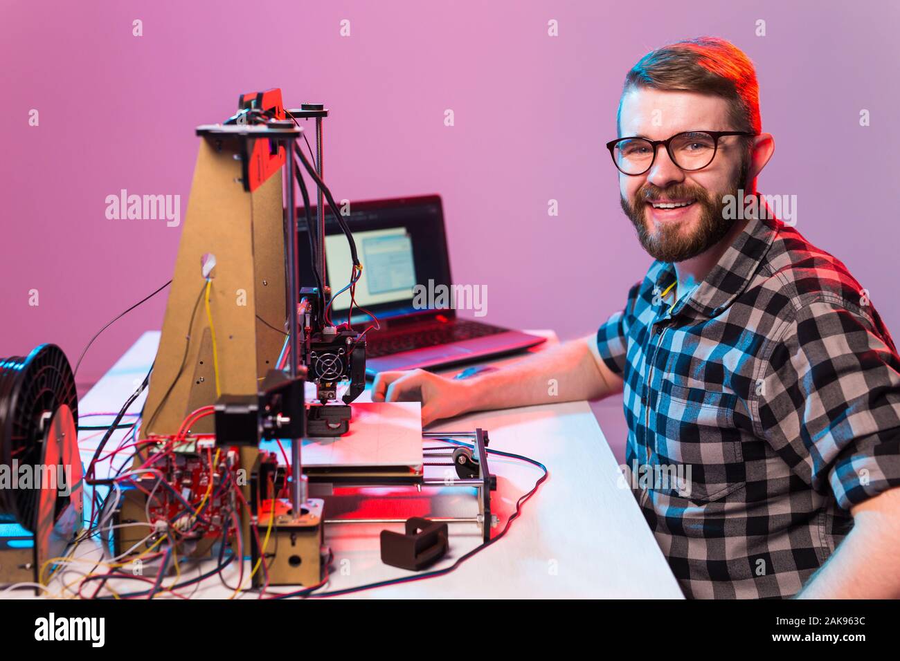 Young male designer engineer using a 3D printer in the laboratory and ...