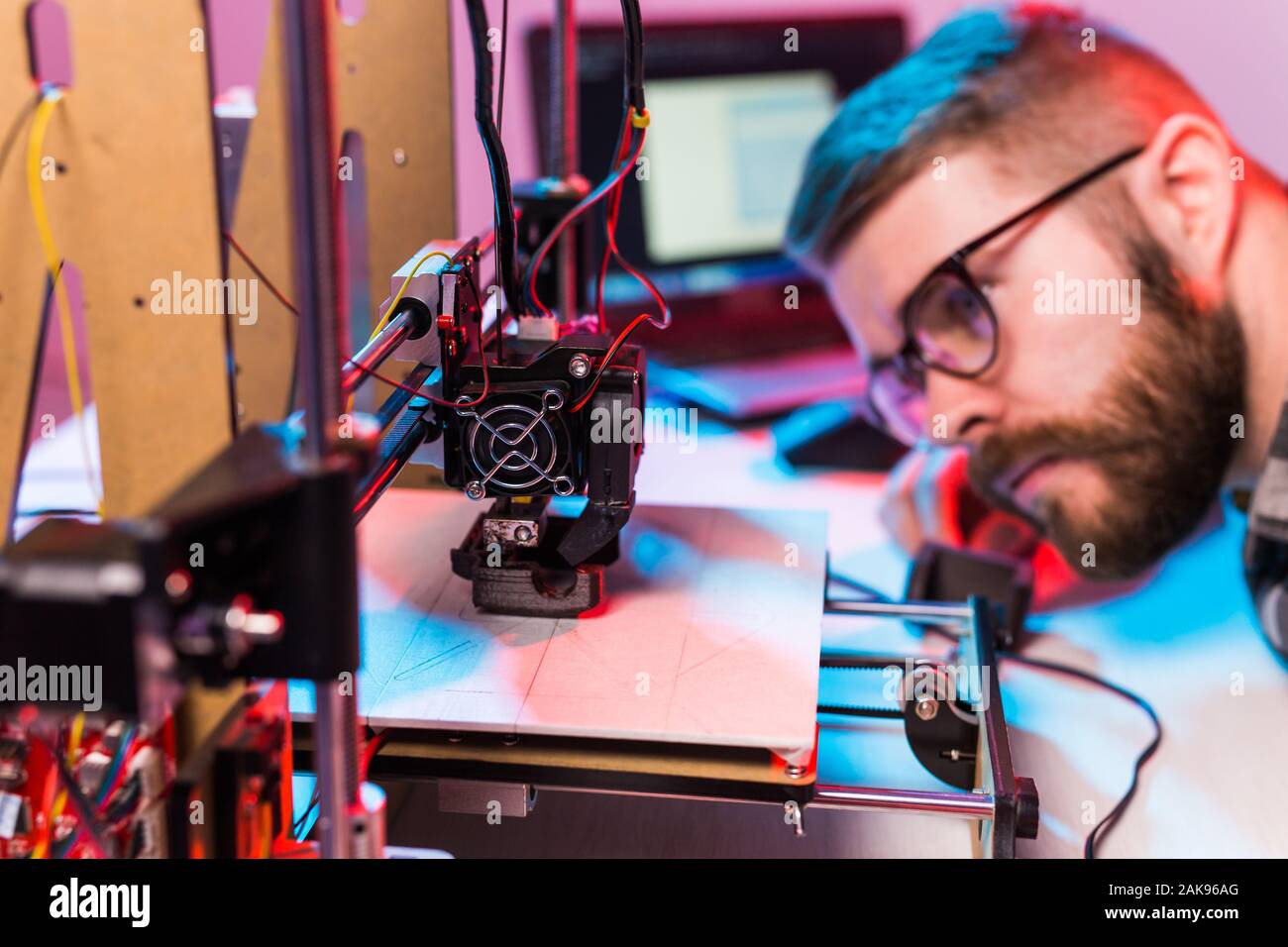 Young male designer engineer using a 3D printer in the laboratory and ...