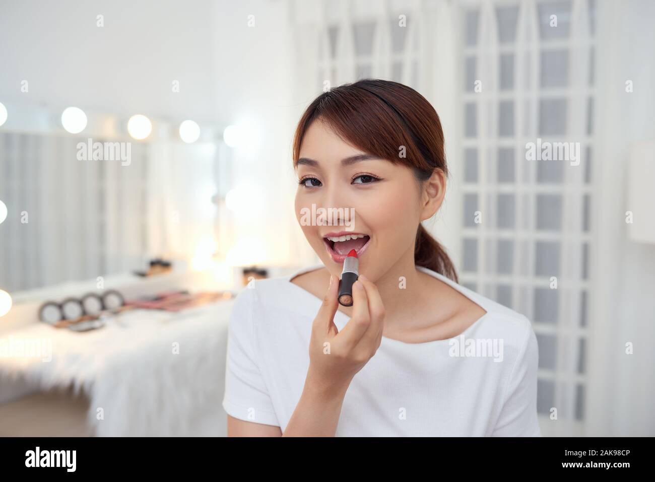 Portrait of Beautiful young Asian girl applying lipstick Stock Photo ...
