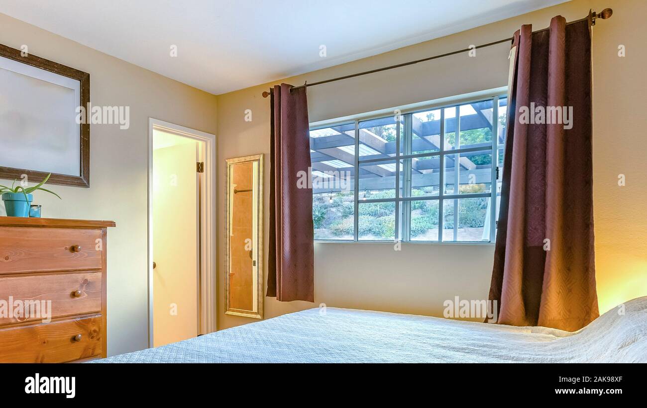 Panorama Lit bedroom of luxury California home with golden light coming ...