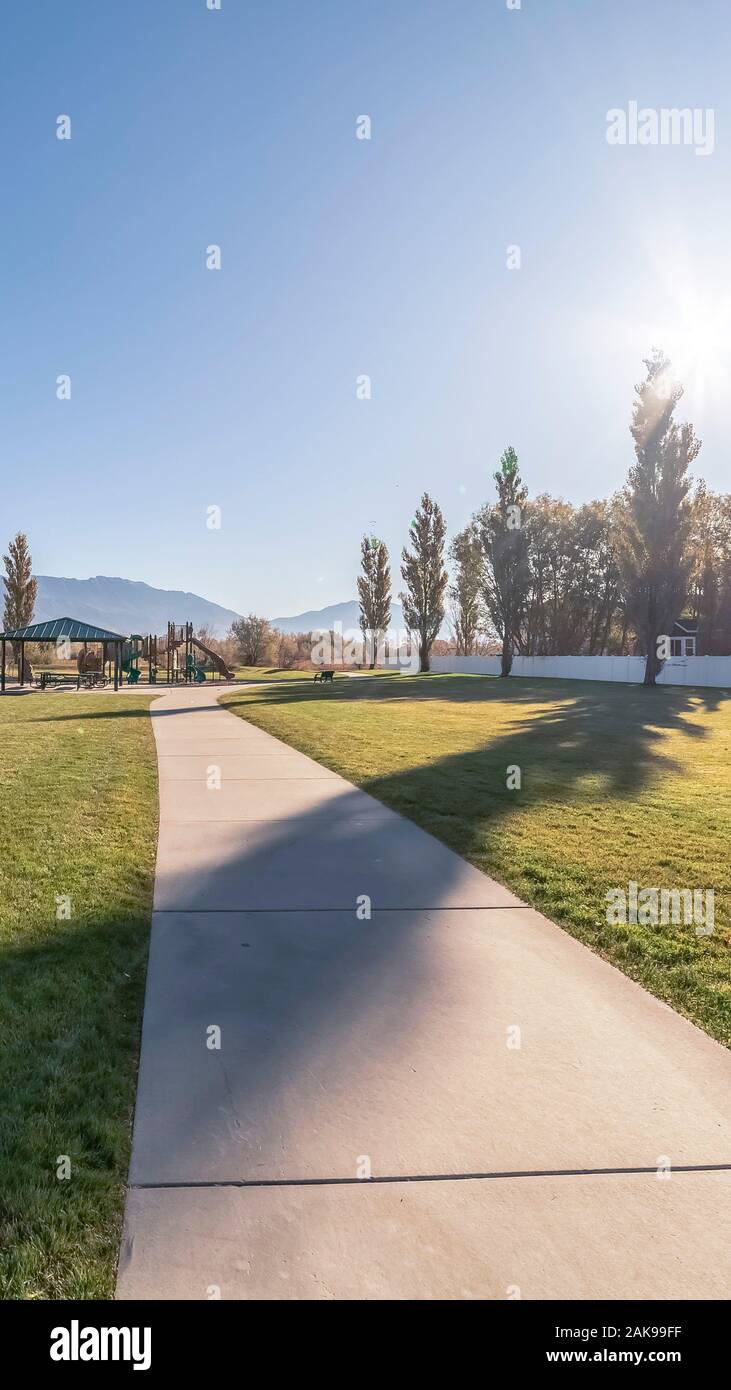 Vertical frame Receding empty paved pathway in a park Stock Photo - Alamy