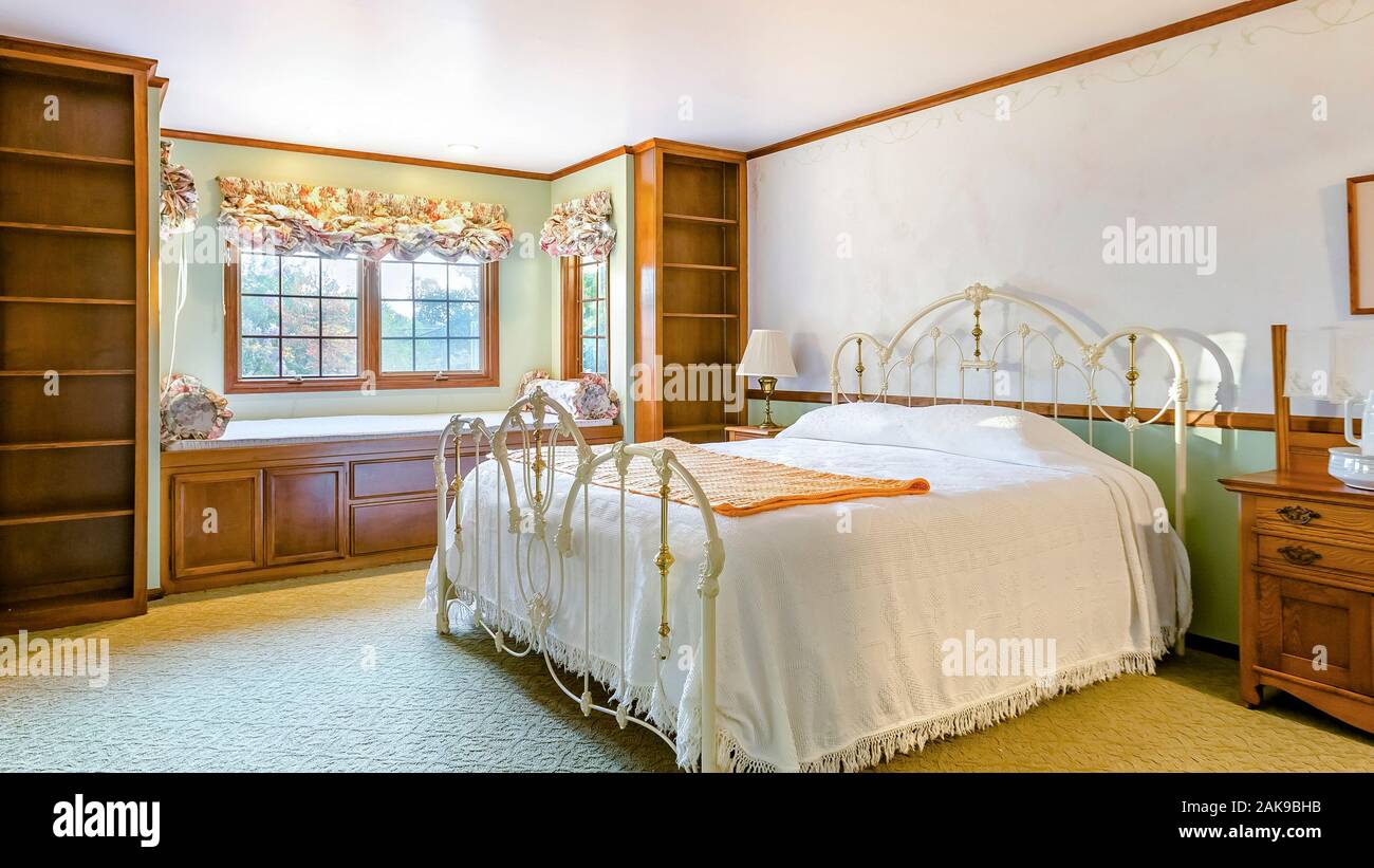 Panorama frame Golden lit bedroom of luxury California home with beige ...