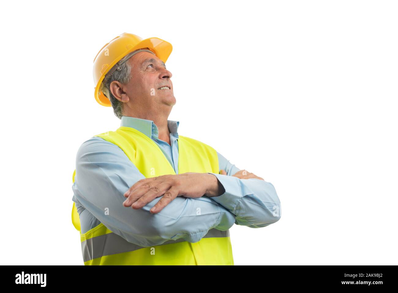 Portrait of old builder man looking up with crossed arms isolated on ...