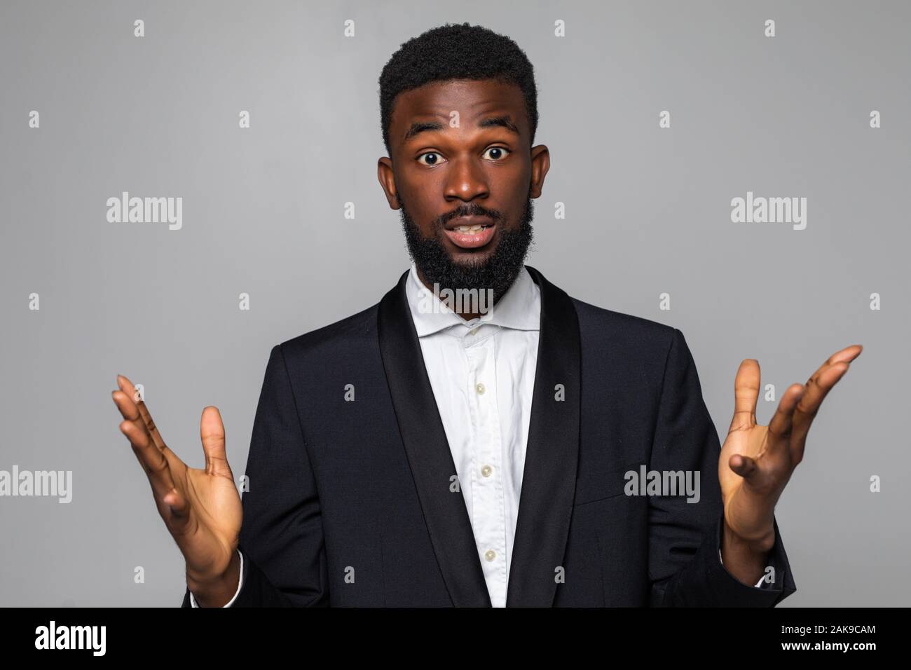 A handsome tall African American man standing in a suit with ...