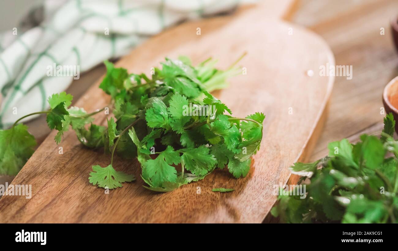 Cutting organic parsley on a wood cuttig board Stock Photo - Alamy
