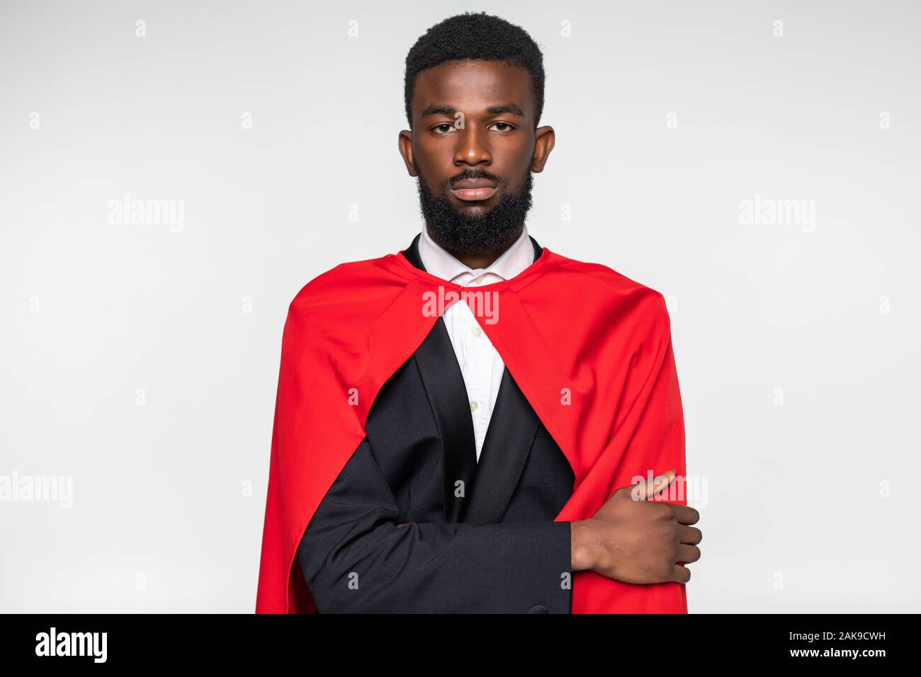 Young african superman pose mood wear formal wear suit isolated grey ...