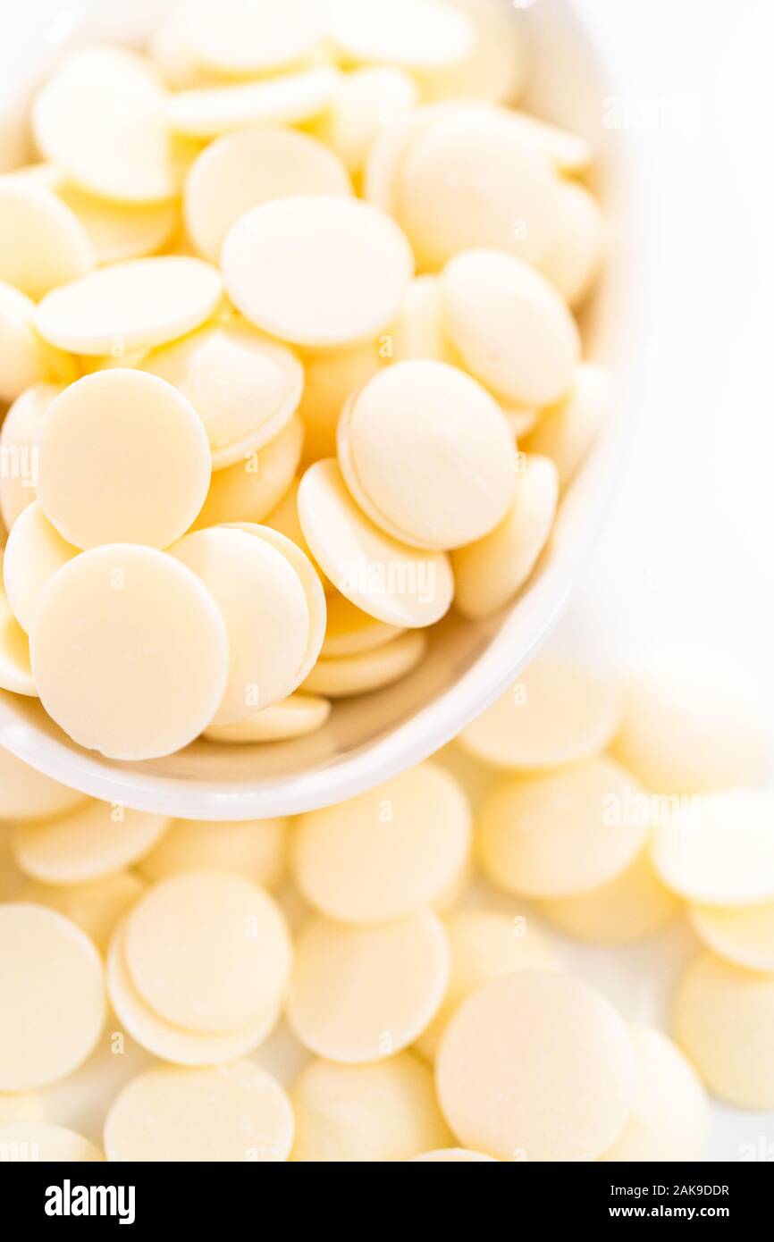 White round chocolate chips for melting chocolate shapes on a white ...