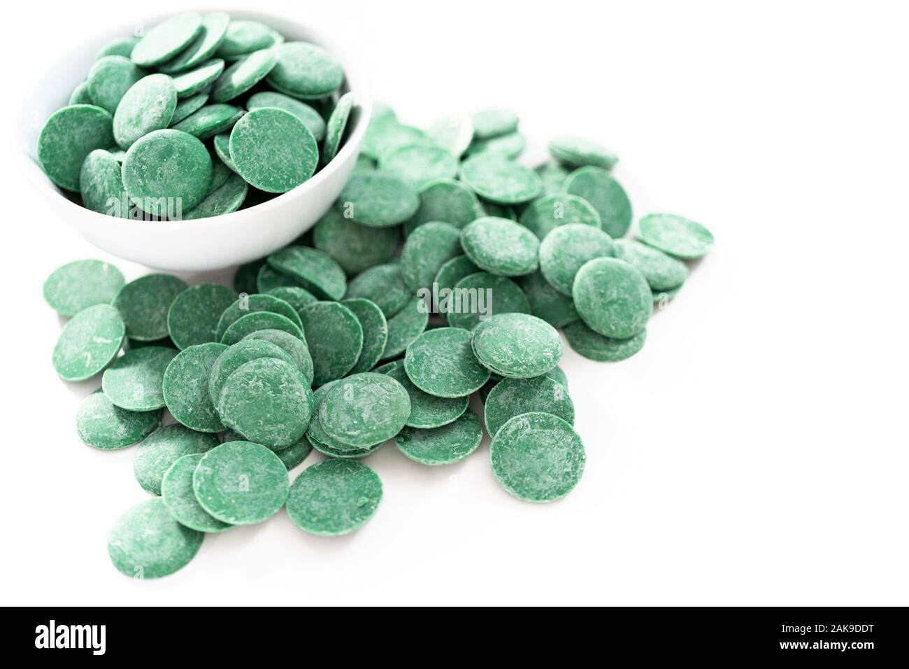 Green round chocolate chips for melting chocolate shapes on a white ...