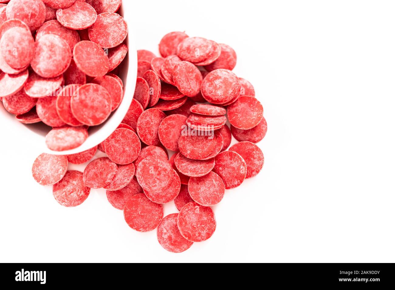 Red round chocolate chips for melting chocolate shapes on a white ...