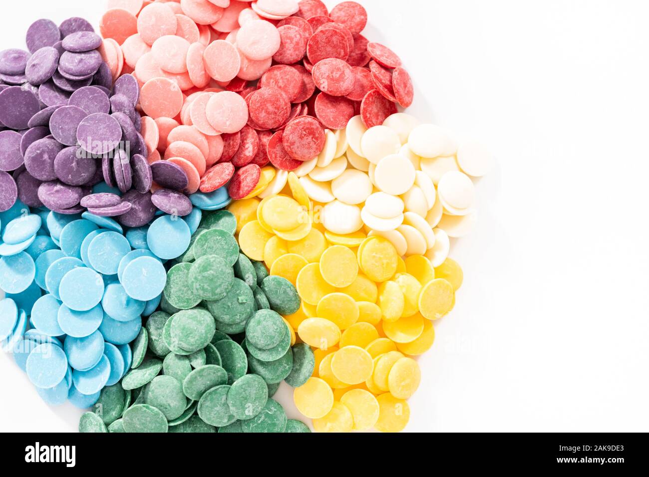 Rainbow colors of round chocolate chips for melting chocolate shapes on ...