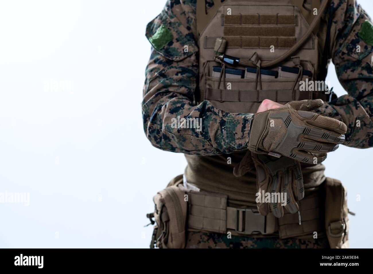 closeup of modern warfare soldier hands putting protective battle ...