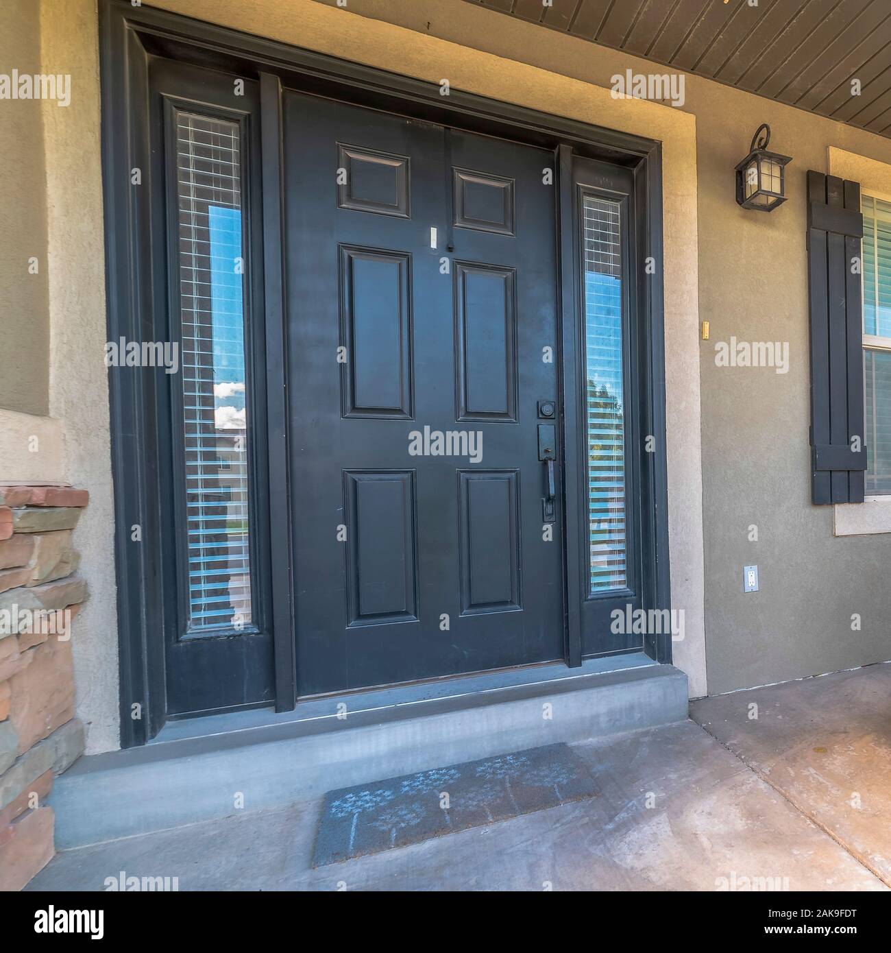 Square Pillars and railing on the porch of a home with gray front door ...
