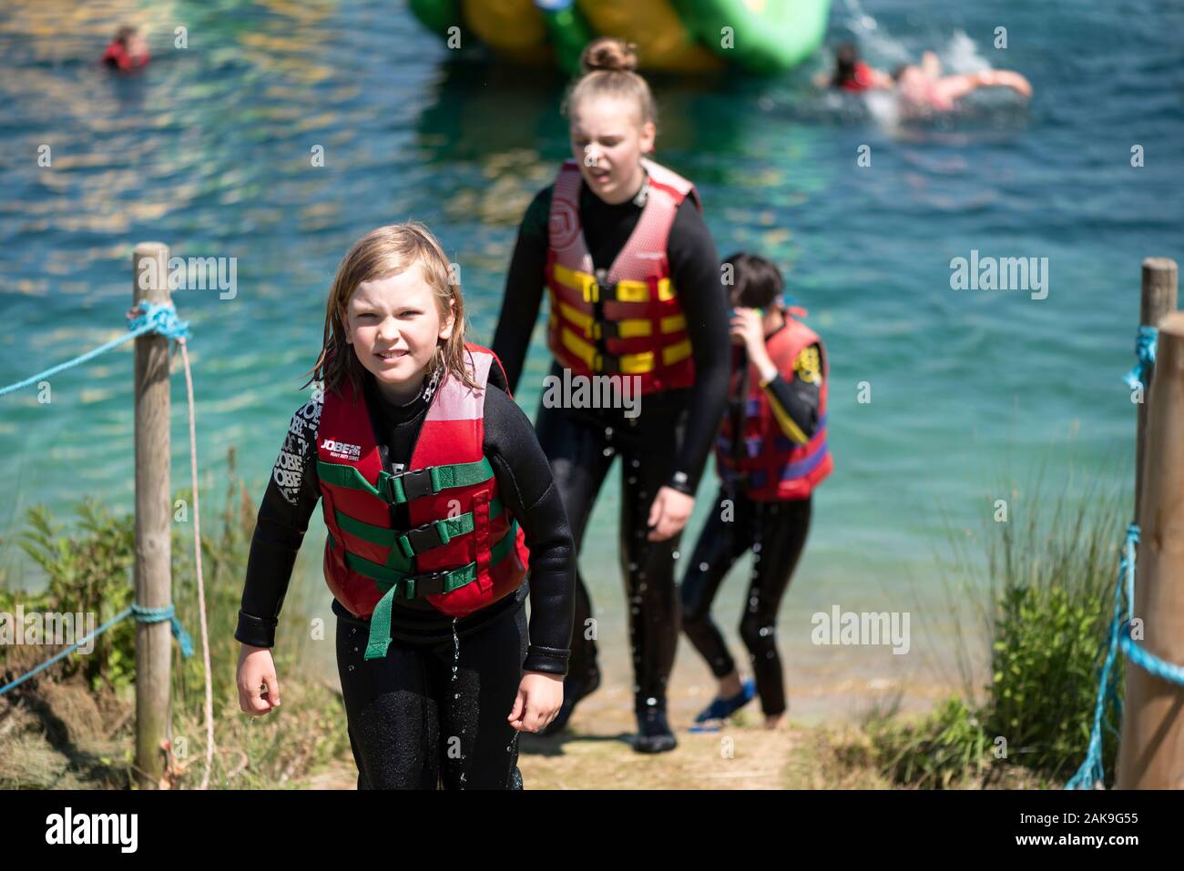 Children in wet suits leaving the water at Box End Aqua Park Stock ...