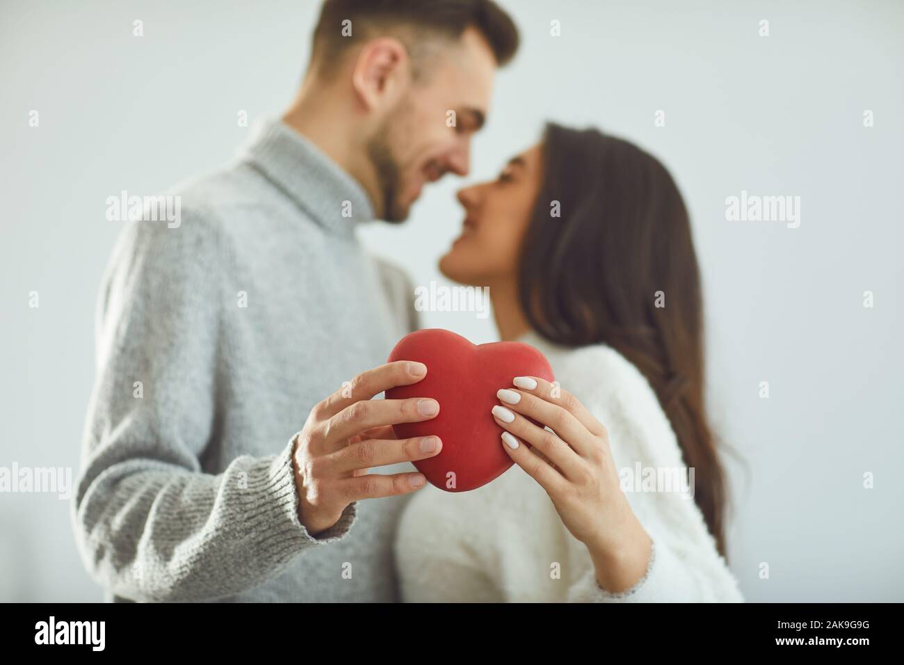 Valentine's day. Loving couple with hearts in hand cuddle in the room ...