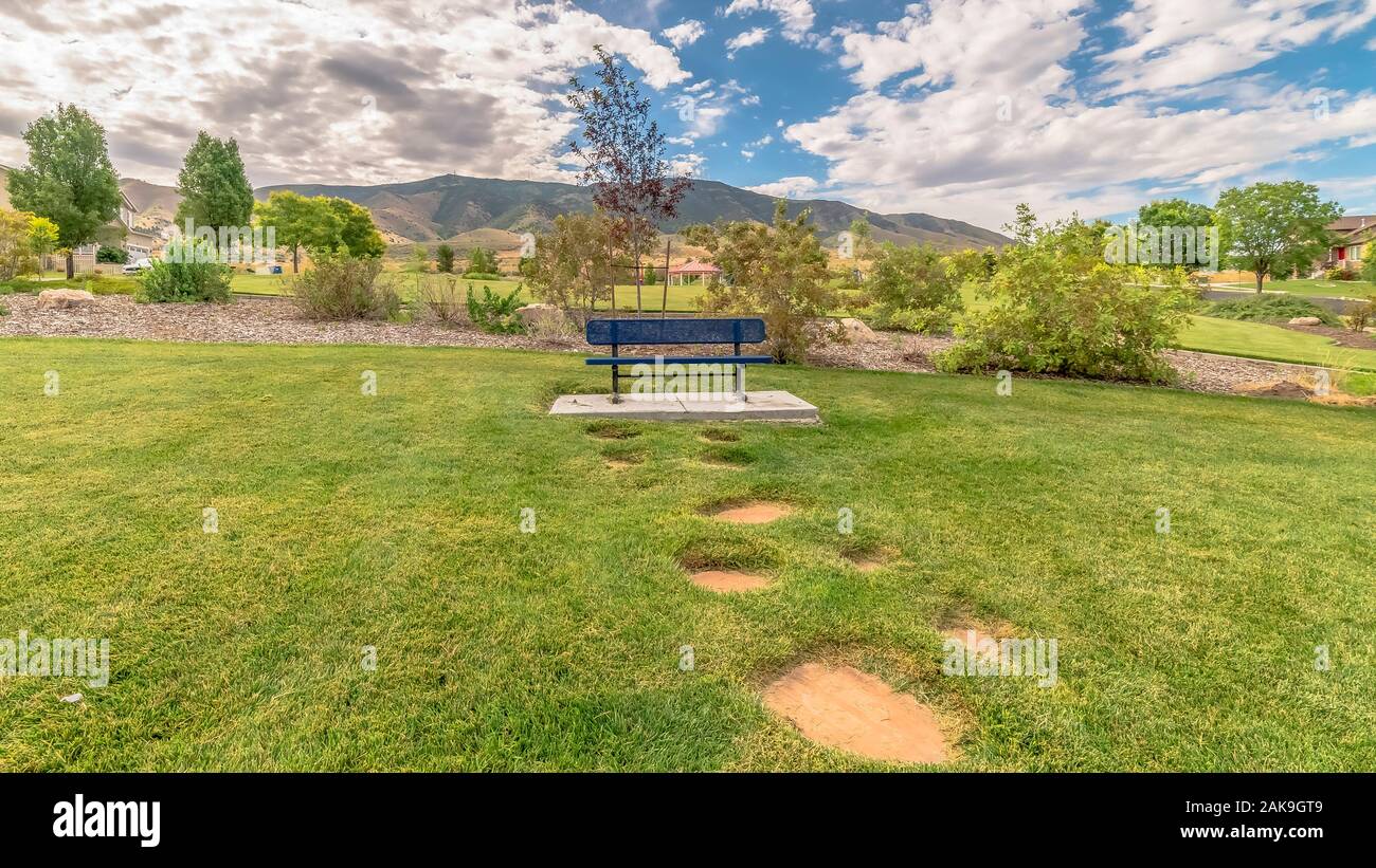 Pano frame Stone steps leading to blue bench with mountain and cloudy ...