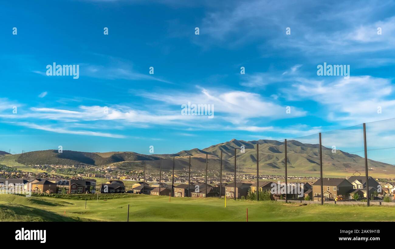 Pano Golf course fairway and putting green with flagsticks under blue ...
