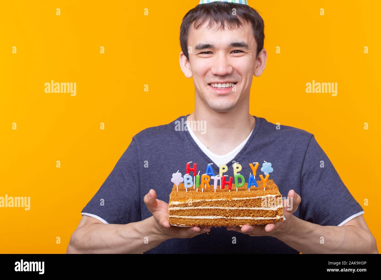 Crazy cheerful young man in glasses and paper congratulatory hats ...