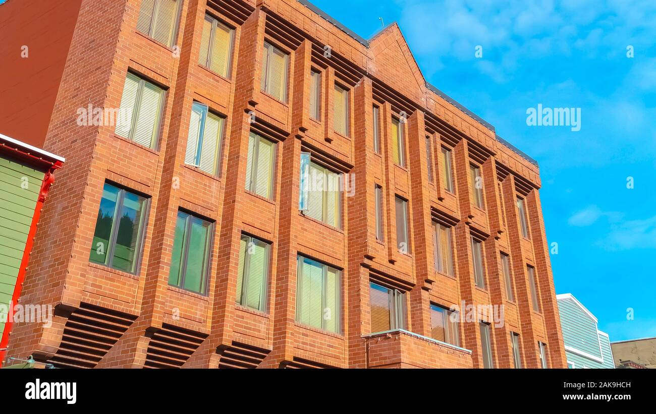 Pano frame Commercial building with red brick wall viewed against blue ...