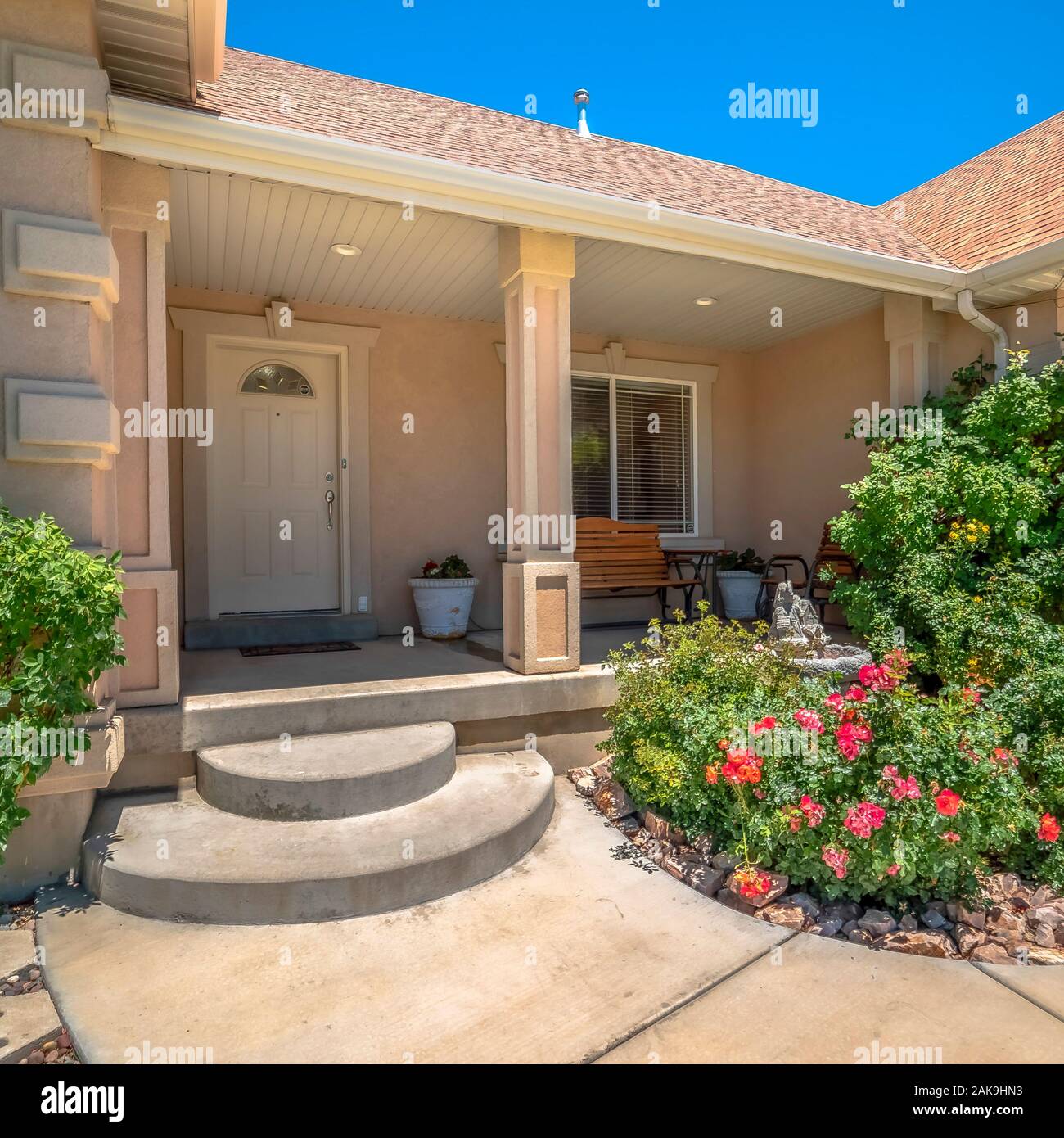 Square Pathway leading to garage and stairs of a home with porch and ...