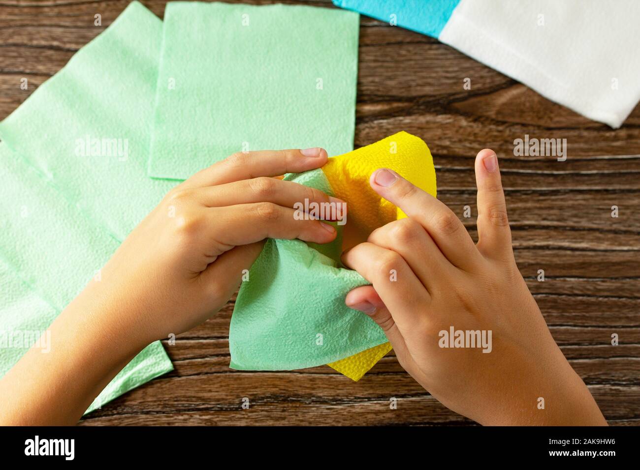 The child adds a flower from napkins. Festive table setting. Handmade ...