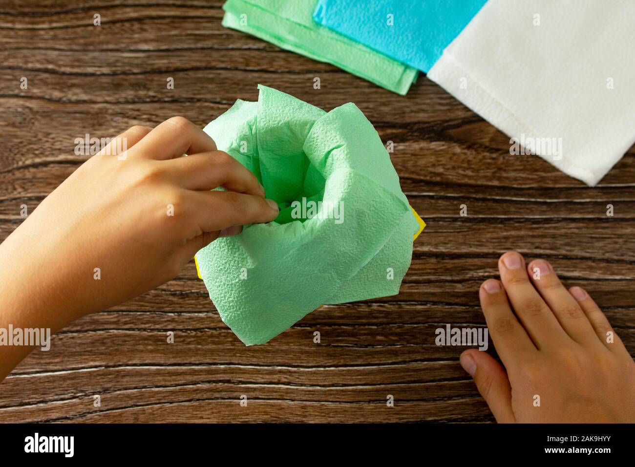 The child adds a flower from napkins. Festive table setting. Handmade ...