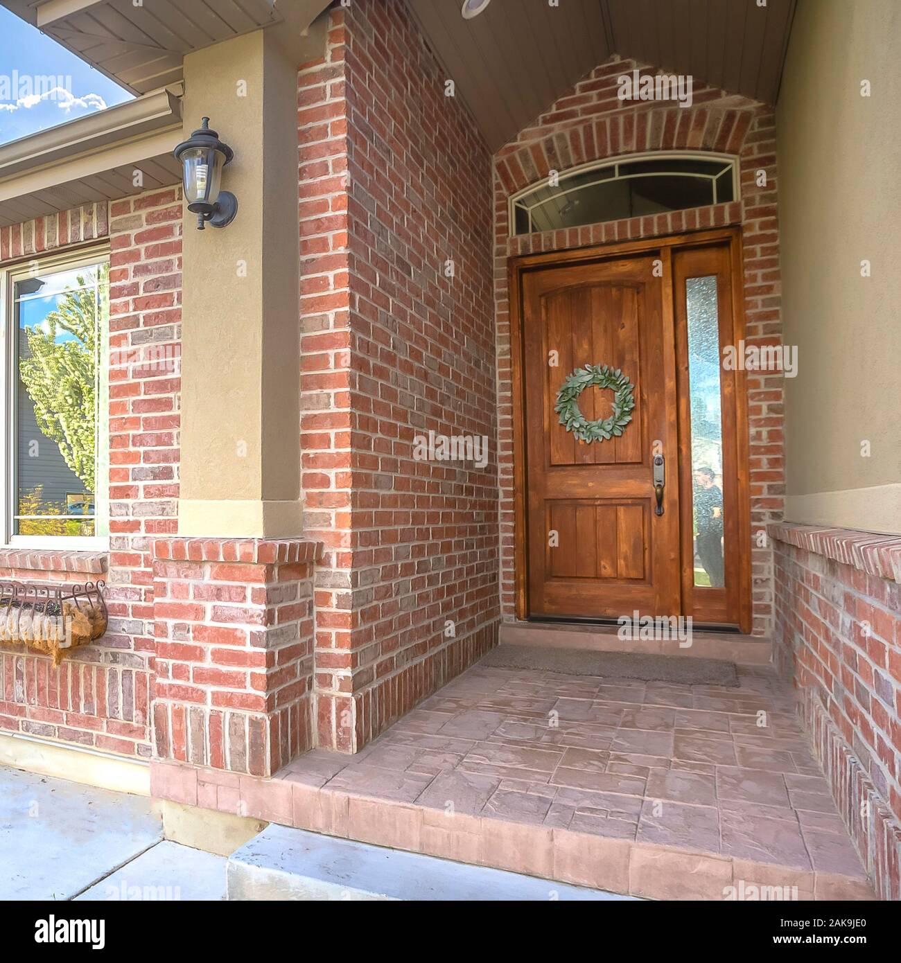 Square Brick house with arched entrance leading to front door with ...