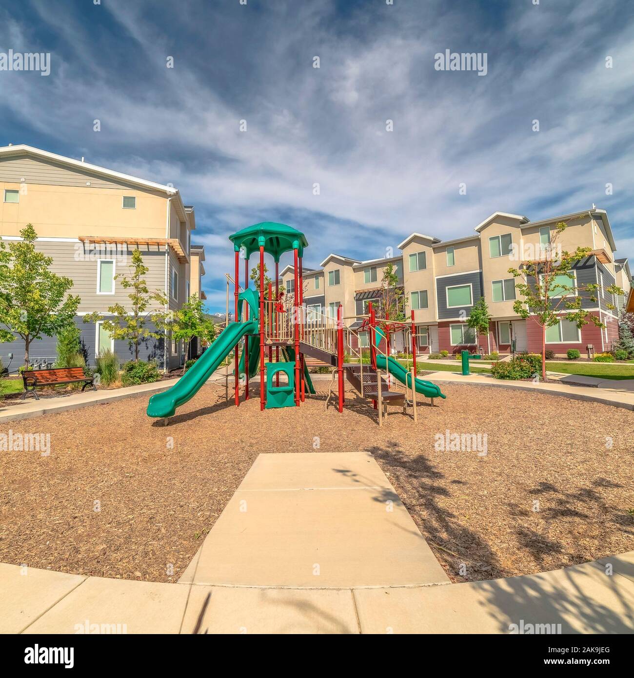 Square Pathway around childrens playground against townhomes and cloudy ...