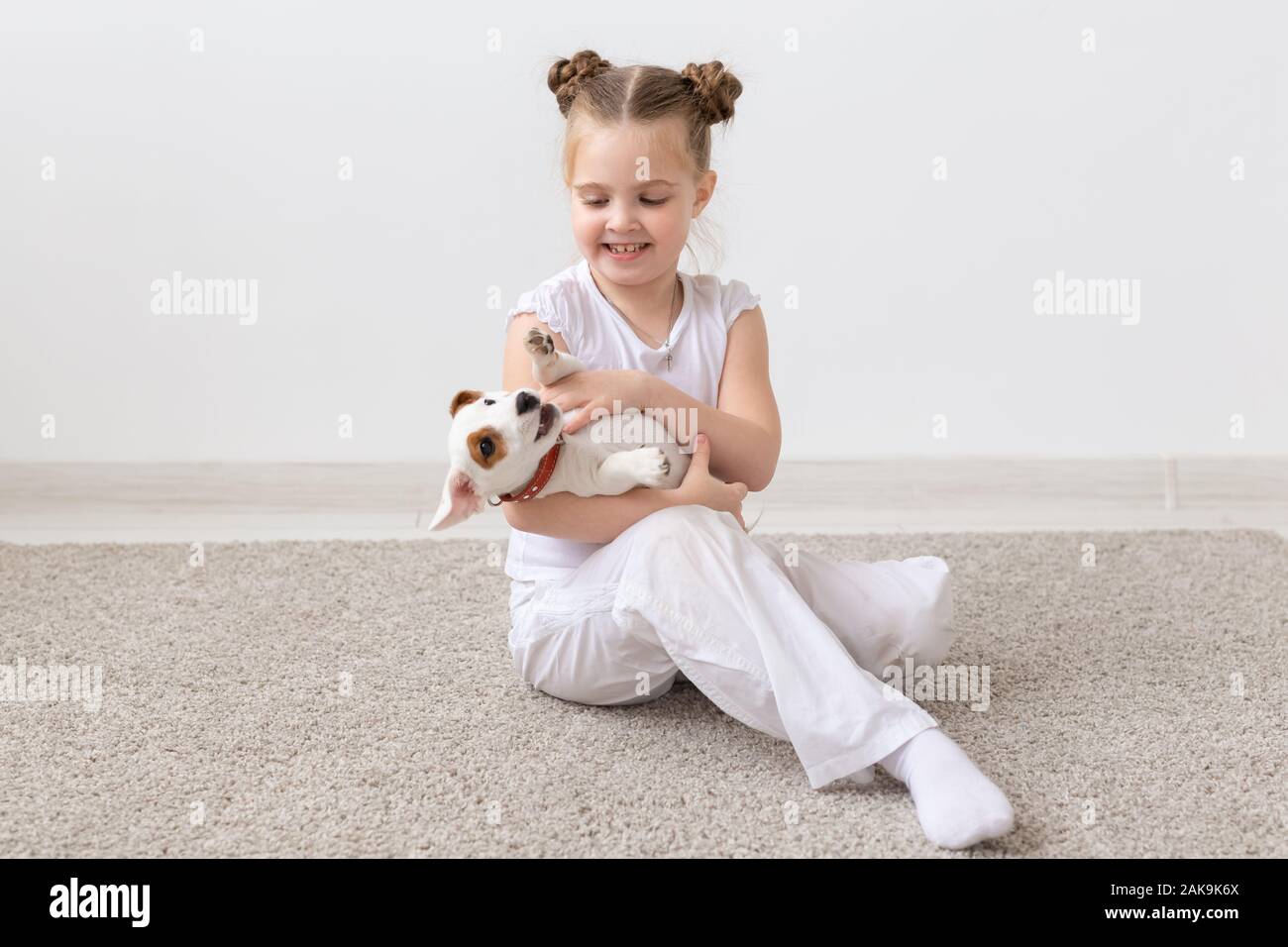 Pet, children and animal concept - Smiling child girl sitting with ...
