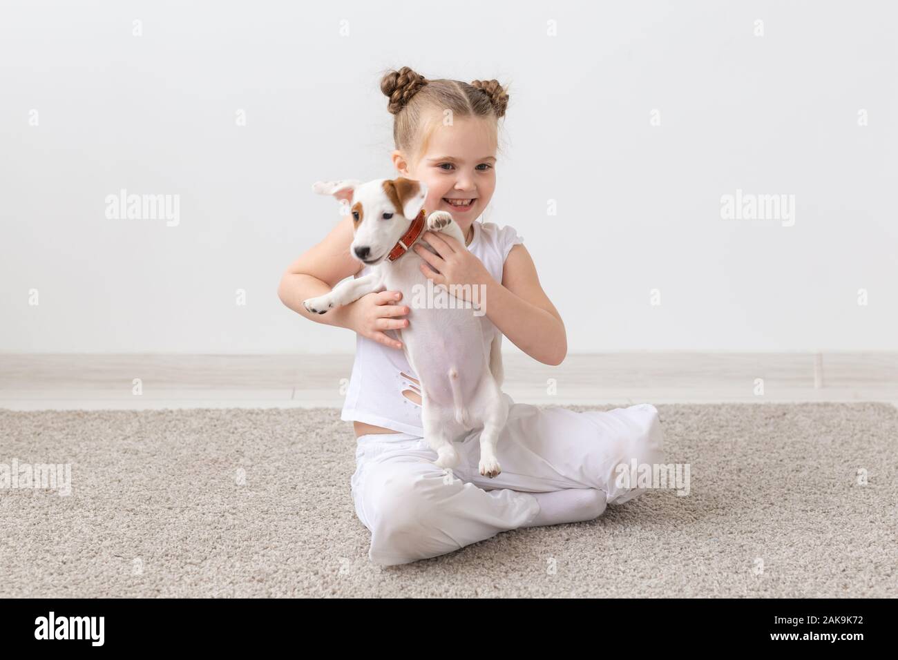 Pet, children and animal concept - Smiling child girl sitting with ...